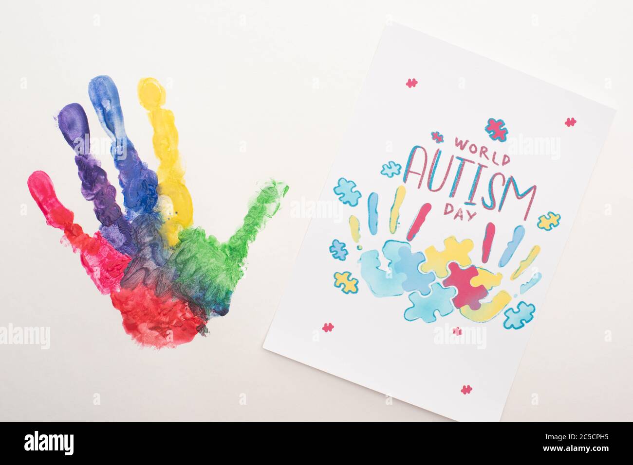 top view of colorful handprint and card with puzzle and World Autism ...