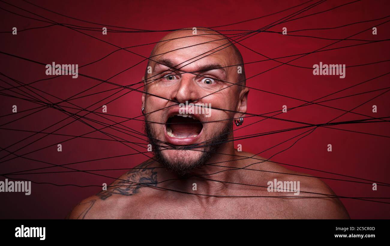 Image of tangled in threads bald screaming man Stock Photo - Alamy