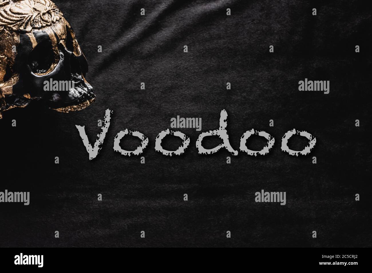 occult skull near voodoo lettering on black Stock Photo - Alamy
