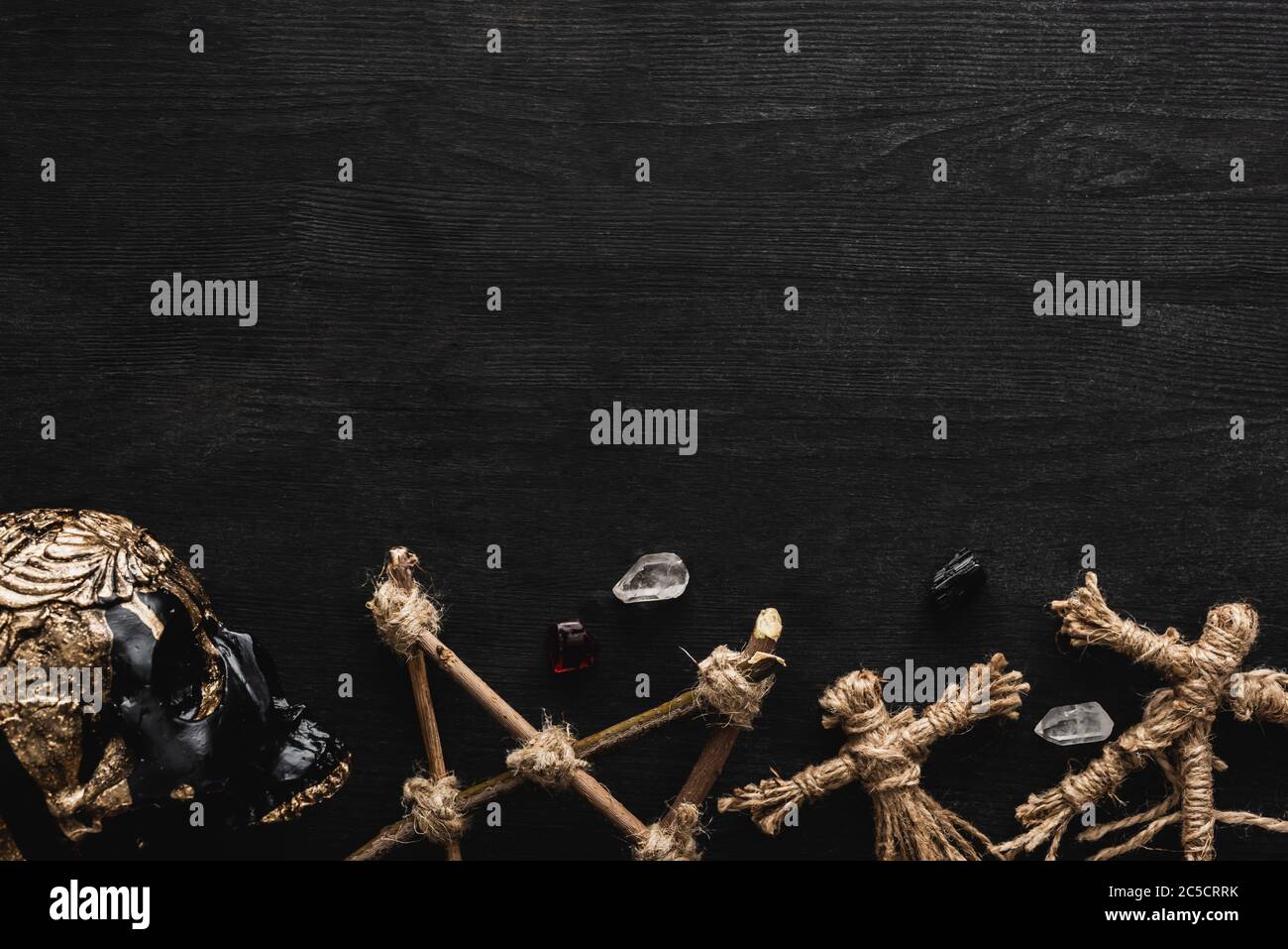 top view of voodoo dolls, ancient crystals, pentagram and skull on ...