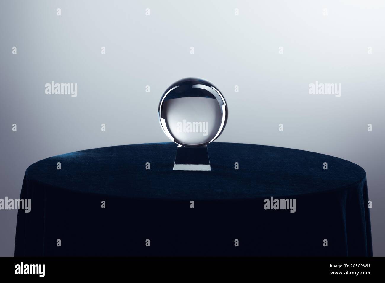 Crystal ball on round table on grey background Stock Photo - Alamy