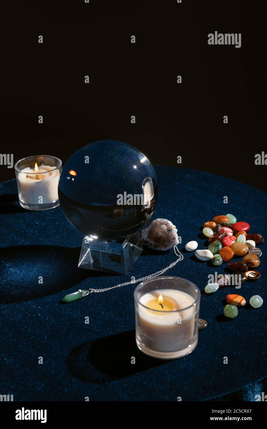 Crystal ball with candles and occult objects on round table isolated on ...