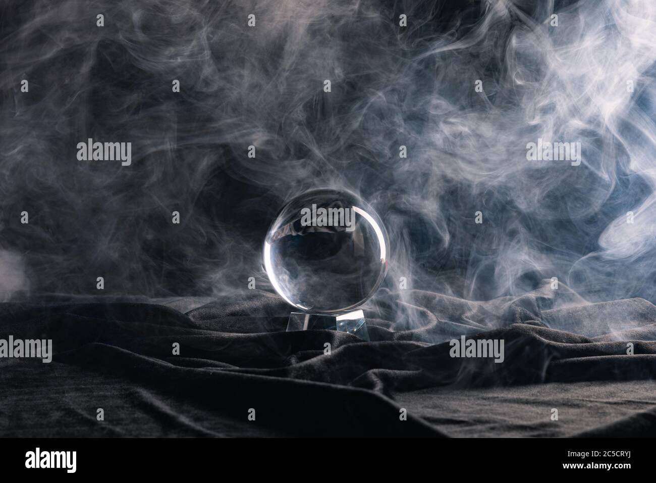 Crystal ball on black textile with smoke on dark background Stock Photo ...