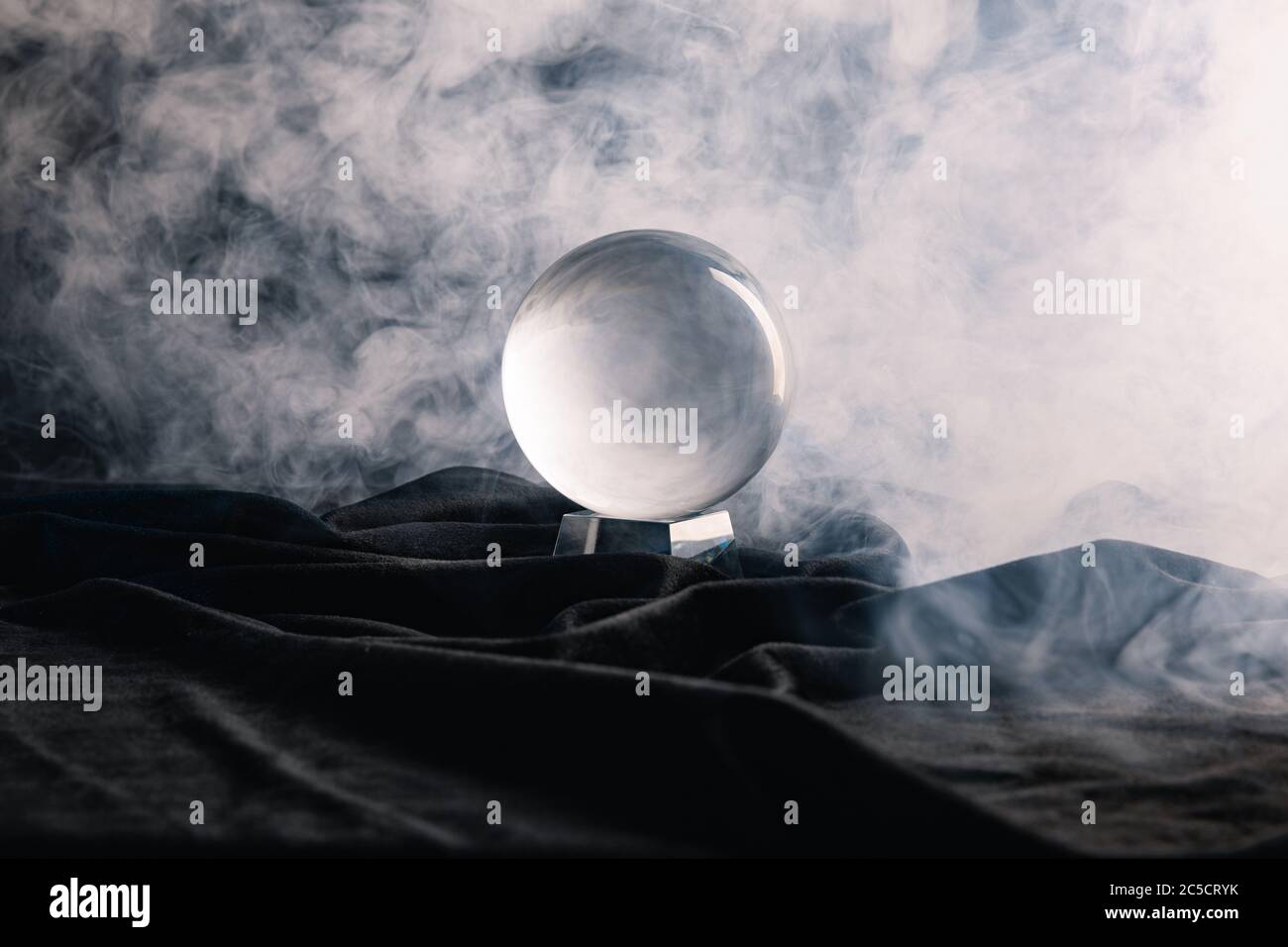 Crystal ball on textile with smoke on dark background Stock Photo - Alamy
