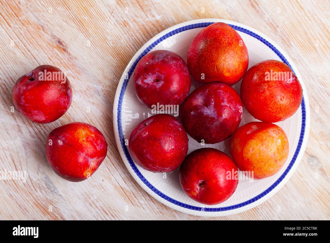 Tasty ripe red plum on a wooden surface. Healthy fruits Stock Photo - Alamy