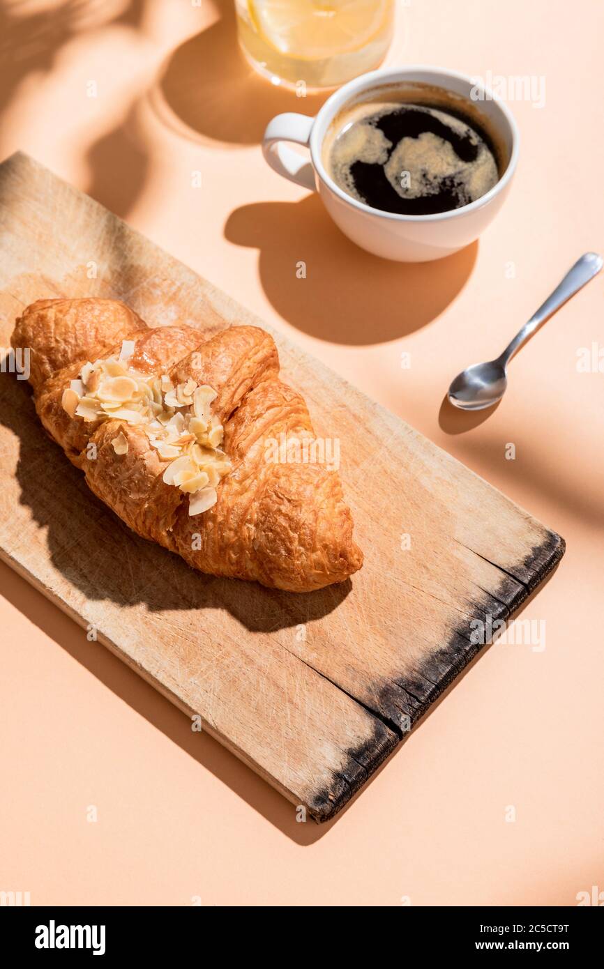 fresh croissants on wooden board and cup of coffee for breakfast on ...