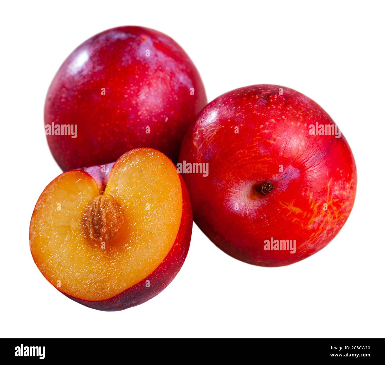 Whole and halved fresh red plums. Isolated over white background Stock ...