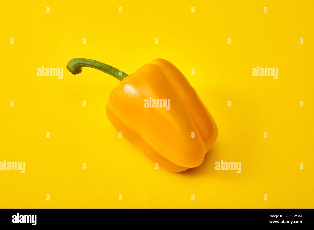 fresh whole bell pepper on yellow background Stock Photo - Alamy