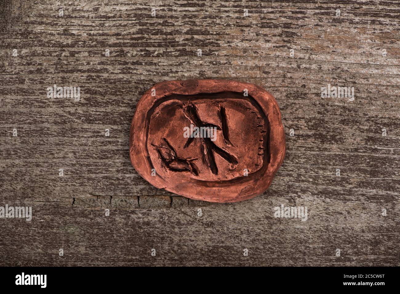 Top view of clay talisman with symbol on wooden background Stock Photo ...