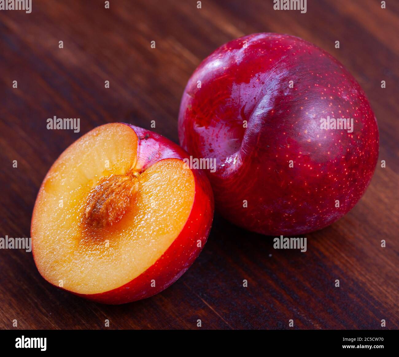 Sliced fresh juicy red plums on wooden table. Concept of health ...