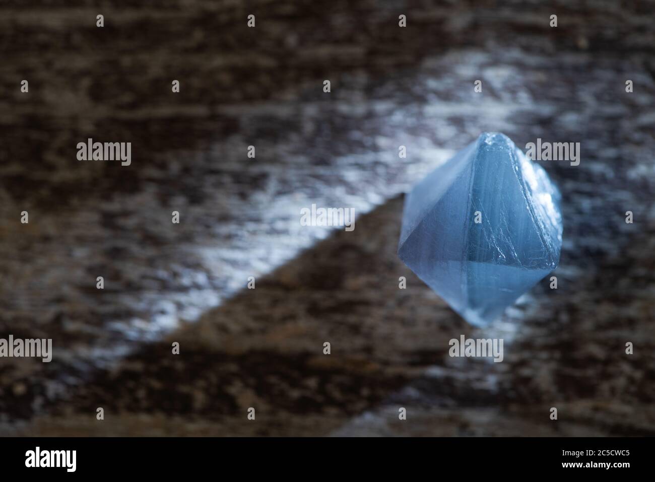 Close up view of blue magic crystal on wooden surface with light Stock ...