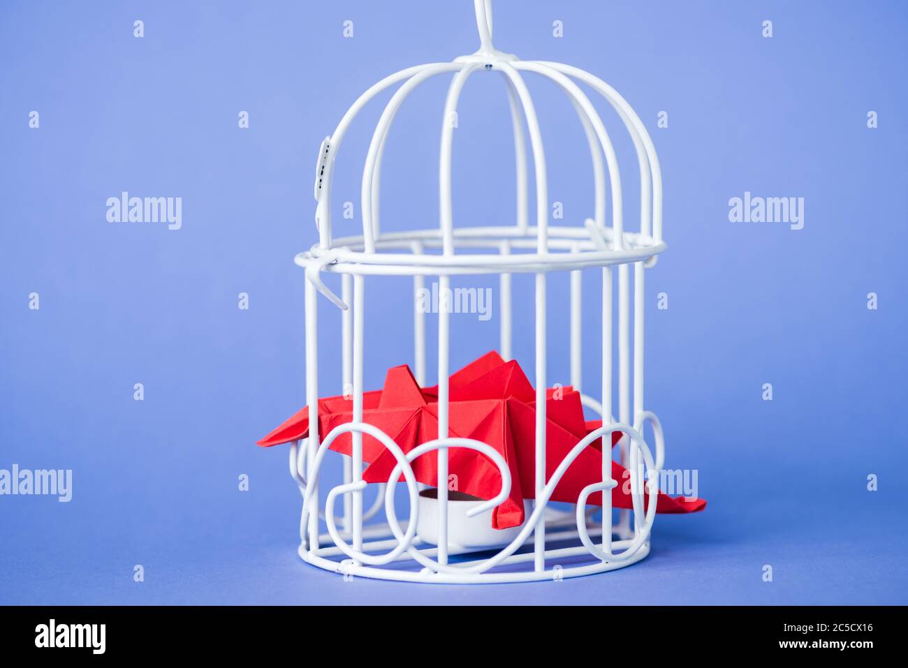 origami birds in metallic cage on blue Stock Photo - Alamy