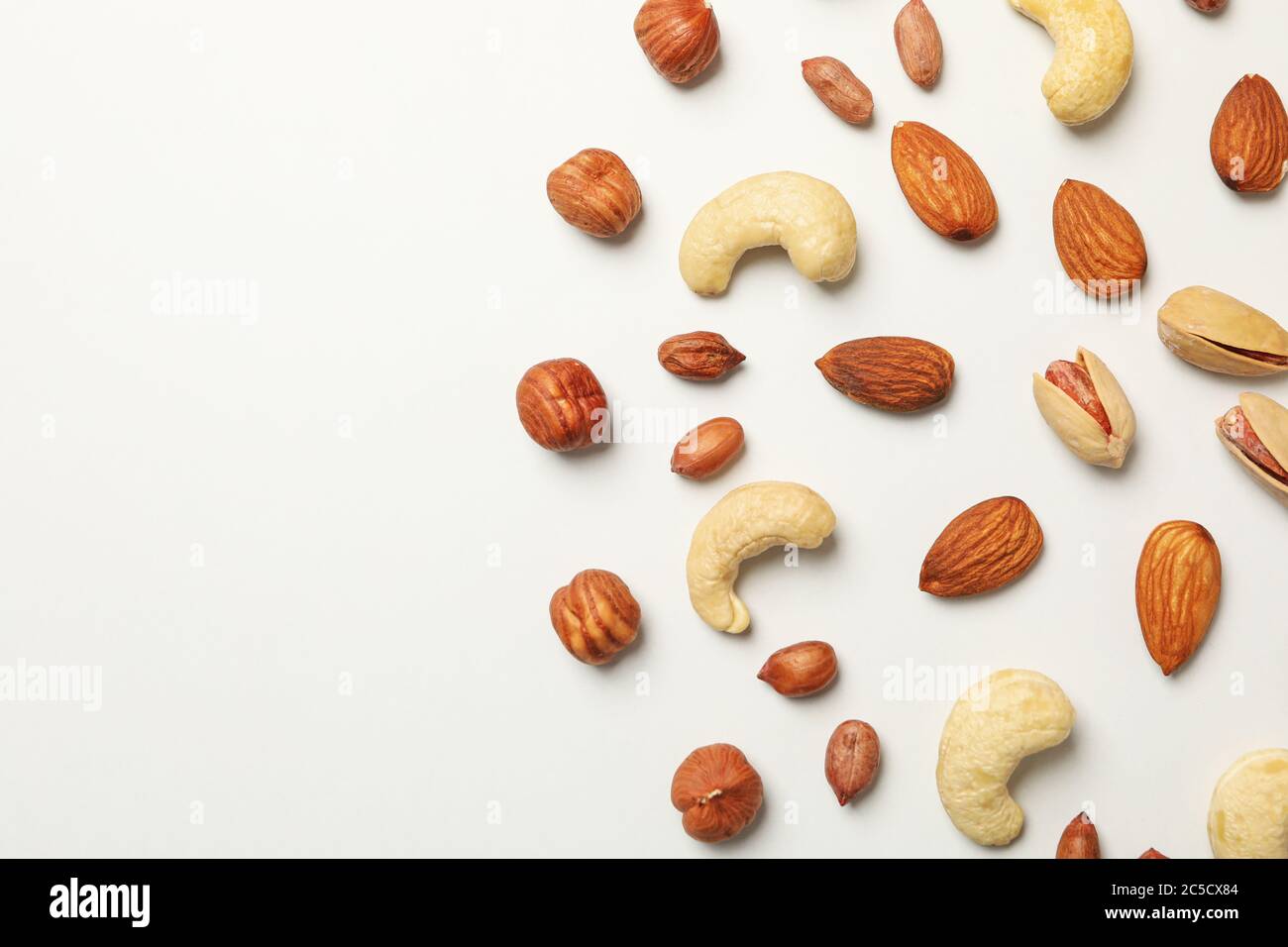 Different tasty nuts on white background. Vitamin food Stock Photo - Alamy