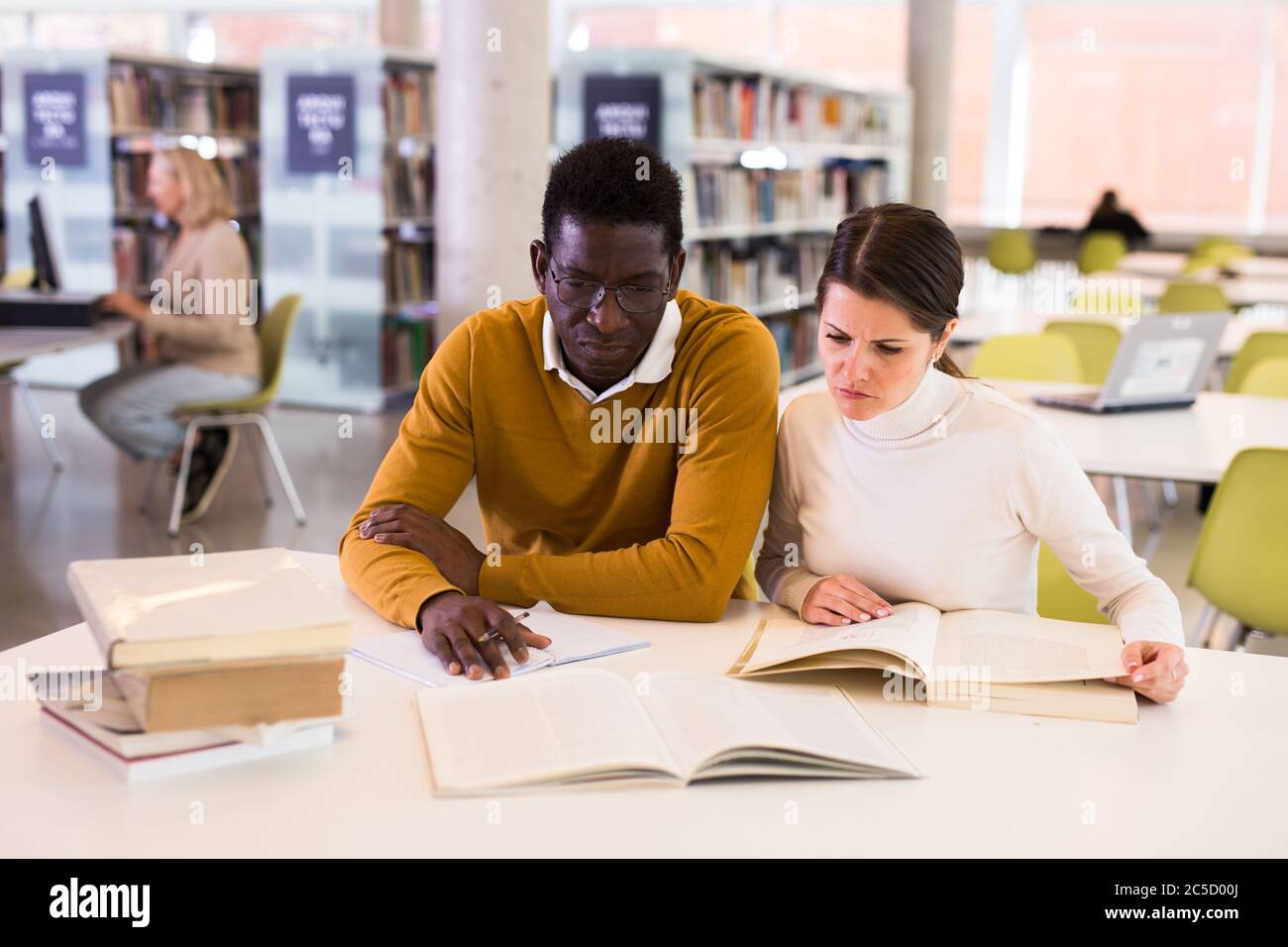 Portrait of couple of adult students studying together in public ...