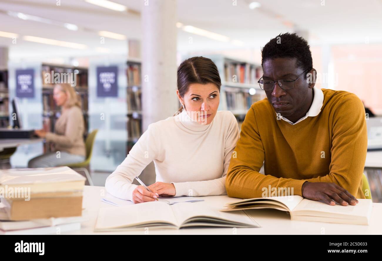 People reading and making notes while preparing for exam in library ...