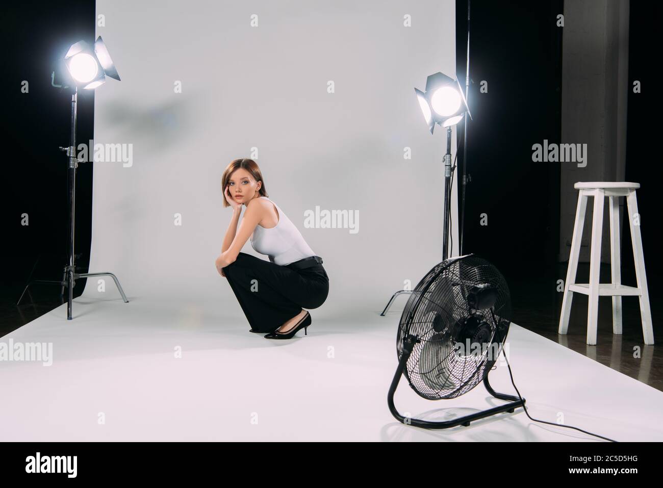 Side view of attractive model looking at camera near floodlights and ...