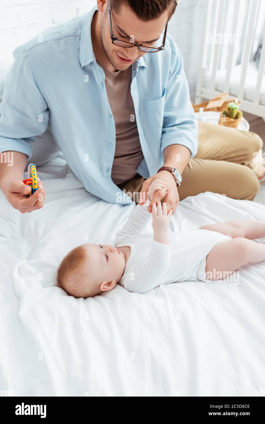 Baby boy holding rattle hi-res stock photography and images - Alamy