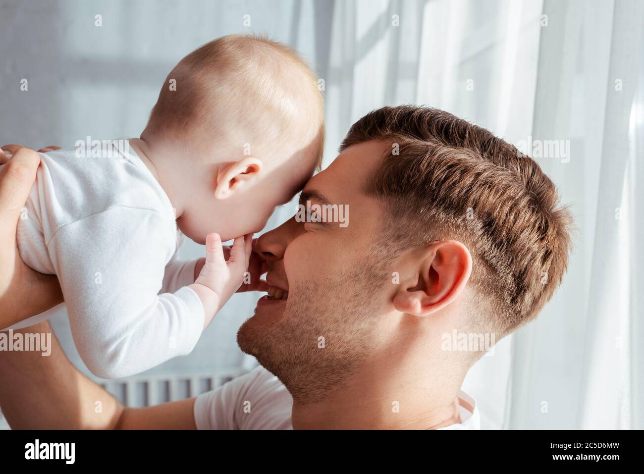 happy father holding adorable boy baby face to face Stock Photo - Alamy