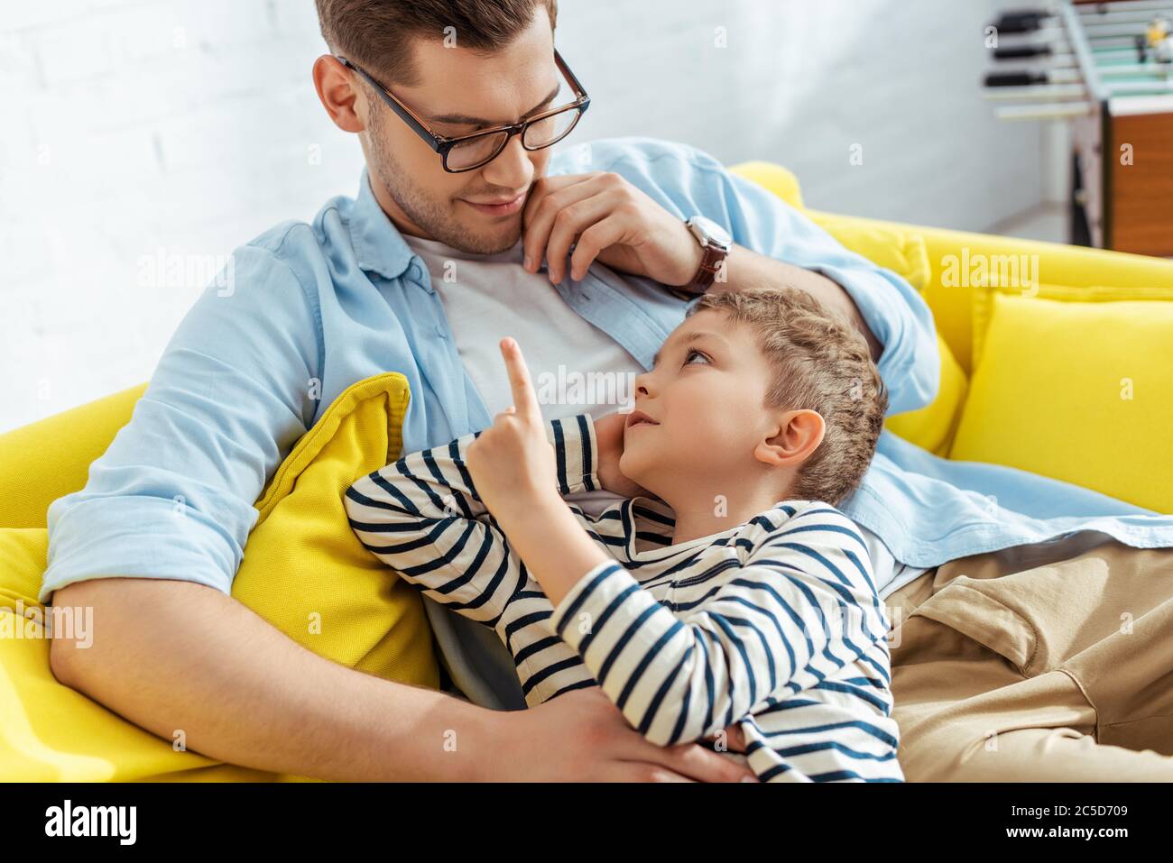adorable kid showing idea gesture while talking to smiling father Stock ...