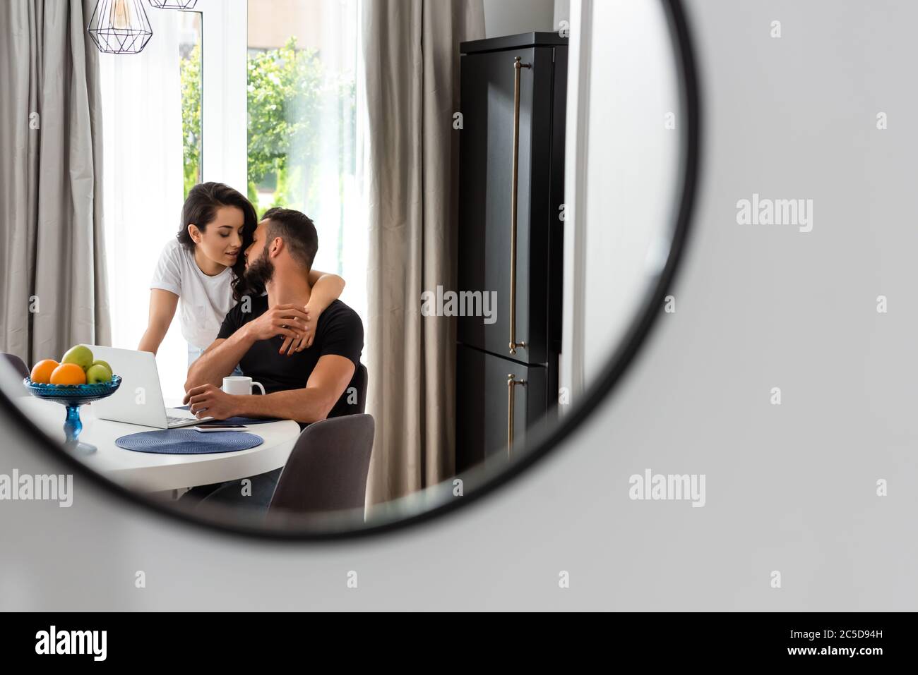 selective focus of mirror with reflection of attractive girl hugging ...