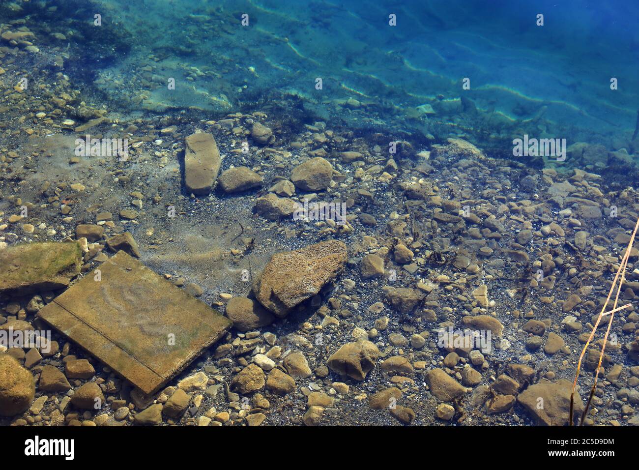 Lakeshore of Lake Aegeri (Ägerisee) with rocks and clear freshwater ...