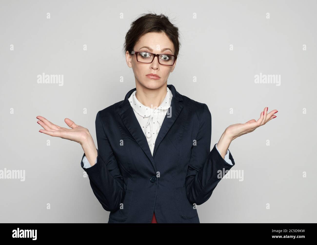 Confused business woman throws up her hands. Isolated on grey Stock ...