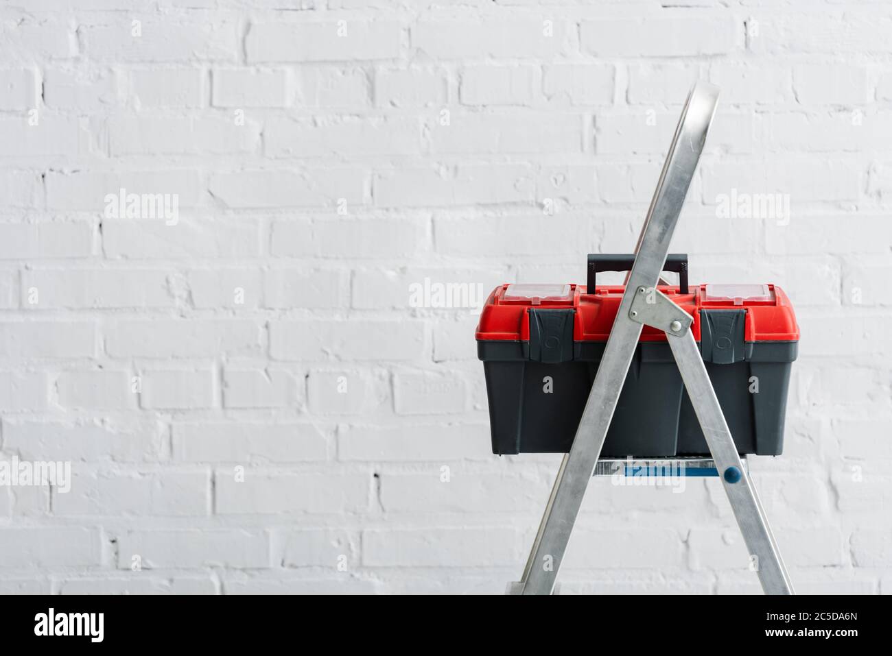 Toolbox on metal ladder near white wall Stock Photo - Alamy