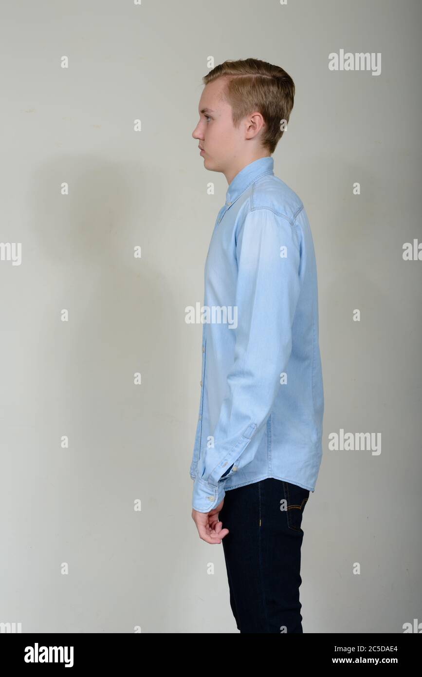 Profile view of young handsome blond teenage boy standing Stock Photo ...