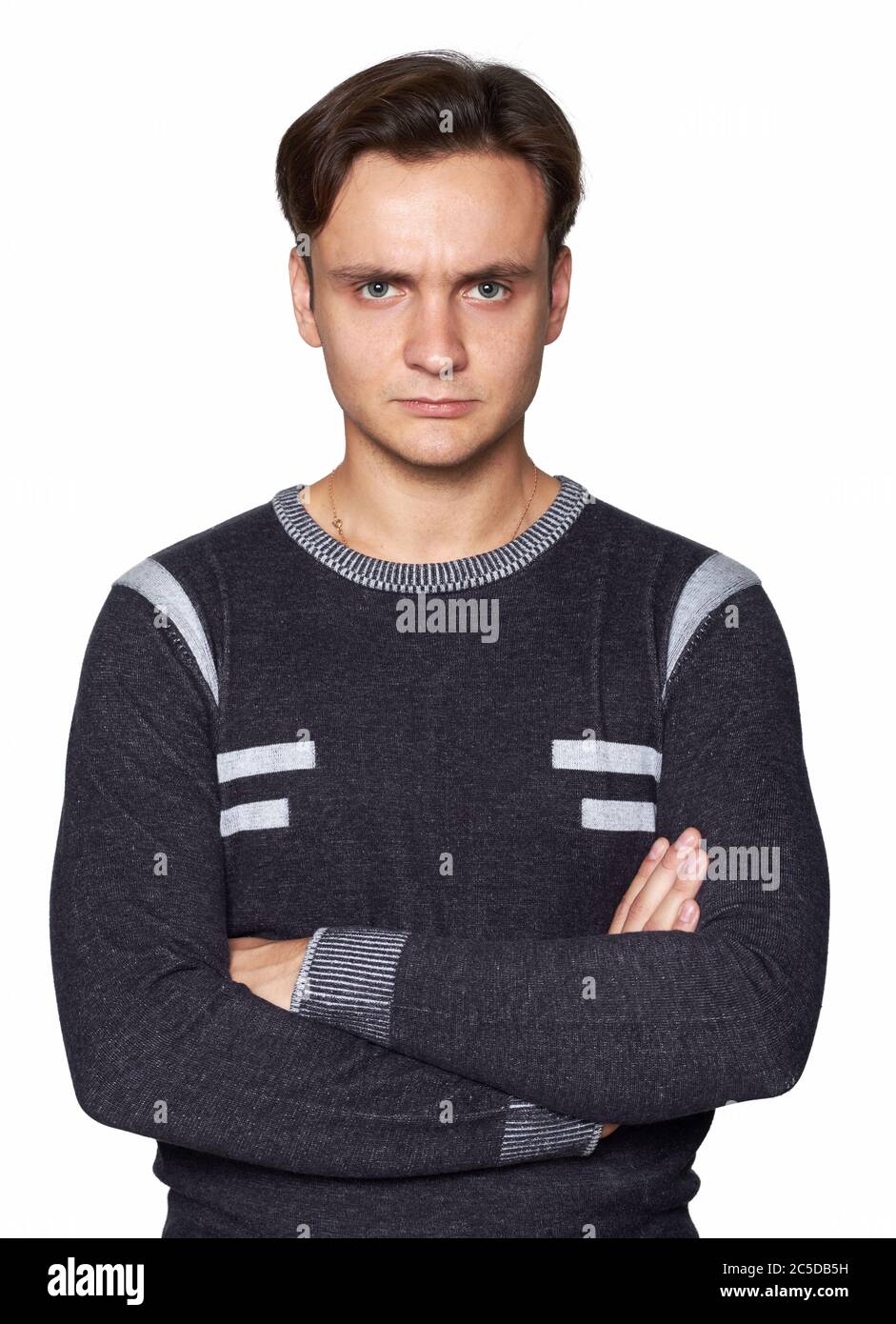 Serious young man with hands folded. Angry guy isolated on gray ...