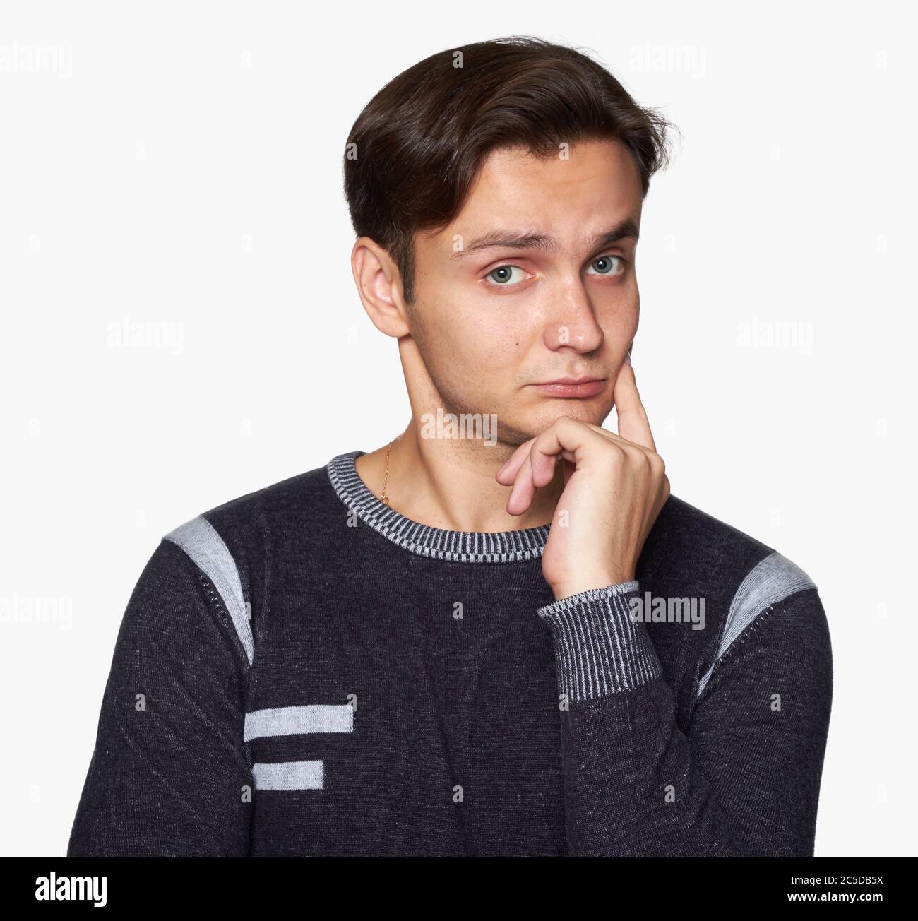 sad man in sweater is thinking. Isolated on gray studio background ...