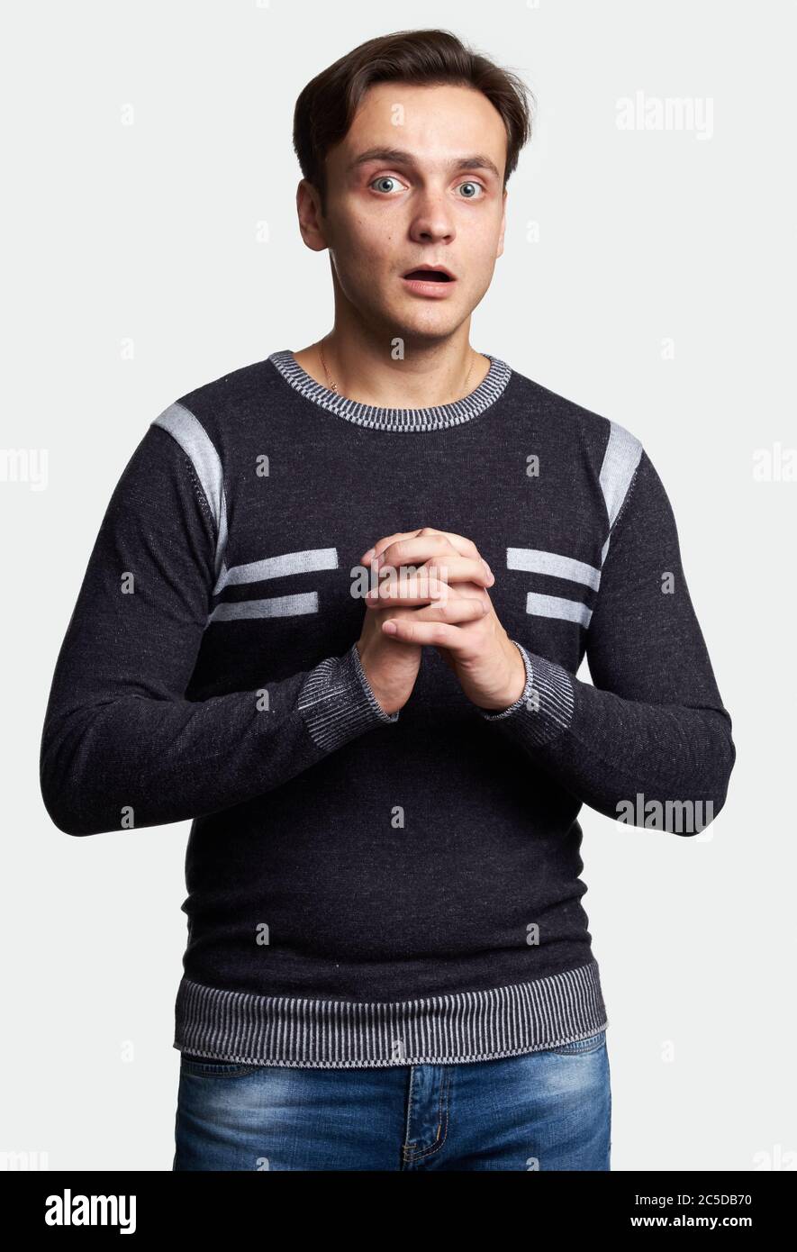 shocked man in sweater and jeans. Isolated on gray Stock Photo - Alamy