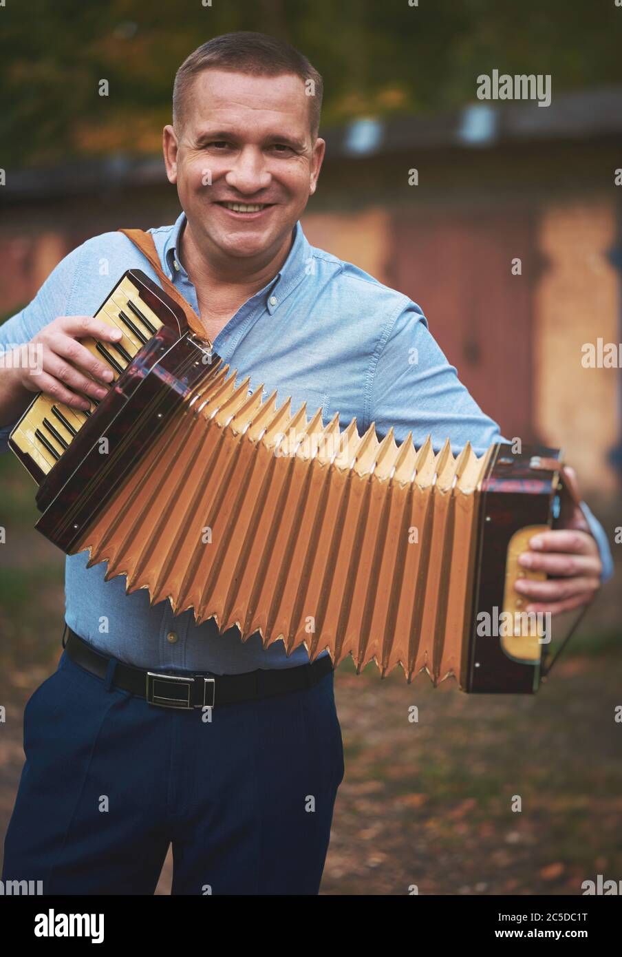 Russian man with accordion. Portable musical instrument, played by ...