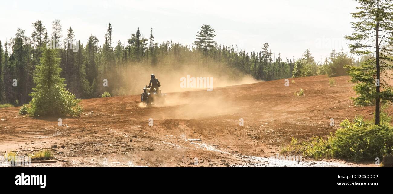 Man driving ATV quad in sandy terrain with high speed Stock Photo - Alamy