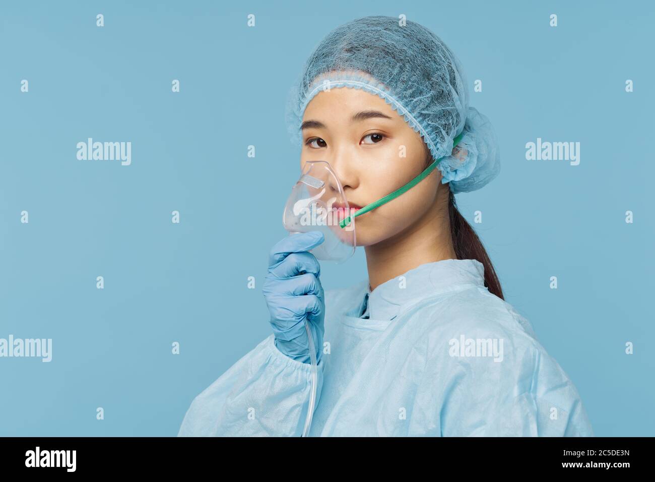 A woman in a medical suit, a cap on her head and an oxygen mask Stock ...