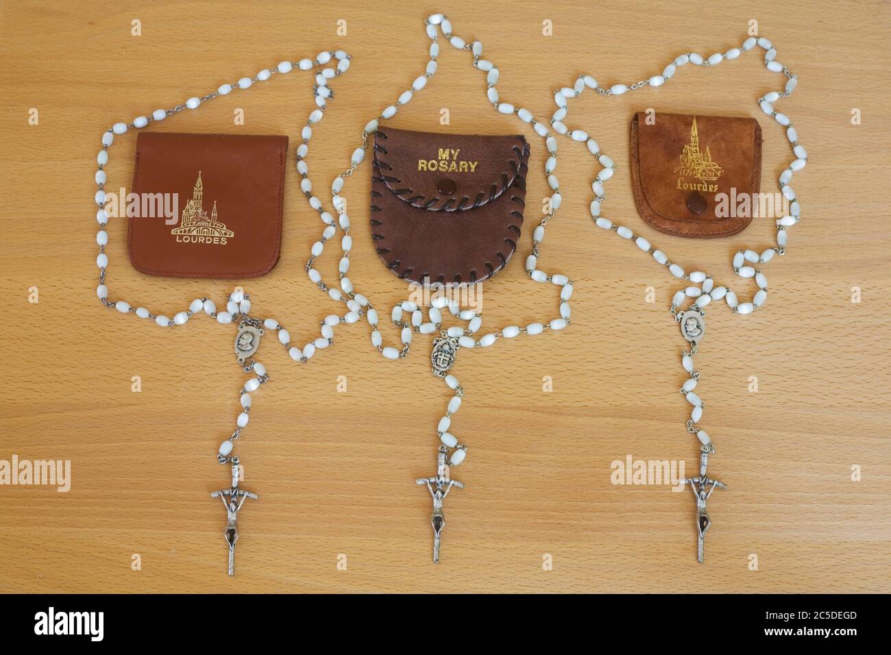 Three plain white sets of rosary beads with Lourdes and personal wallet ...