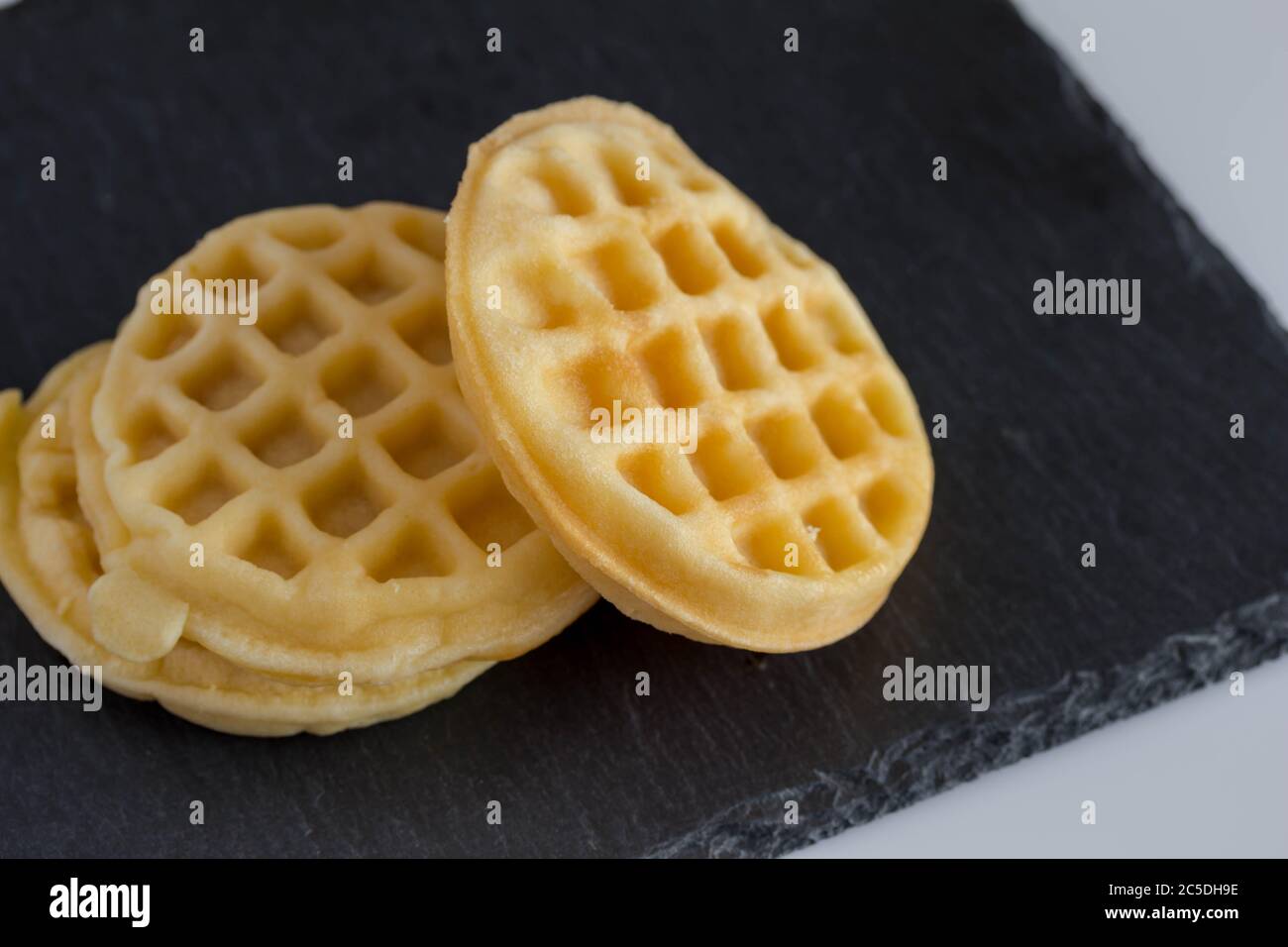 Round small waffles on black slate background waffles with copy space ...