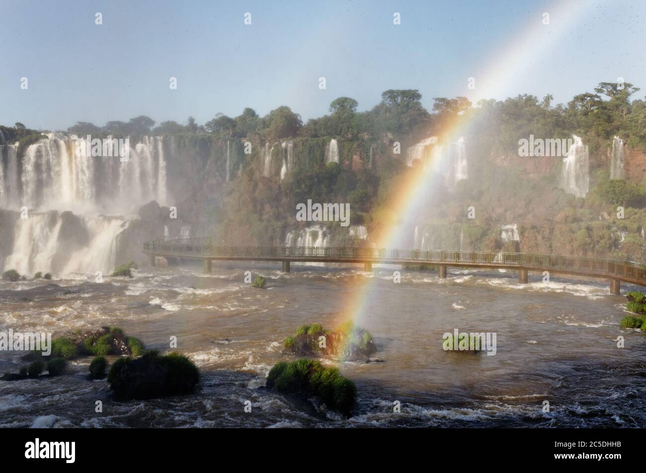 Curved rainbow against a blue sky over Devils Throat waterfall at ...