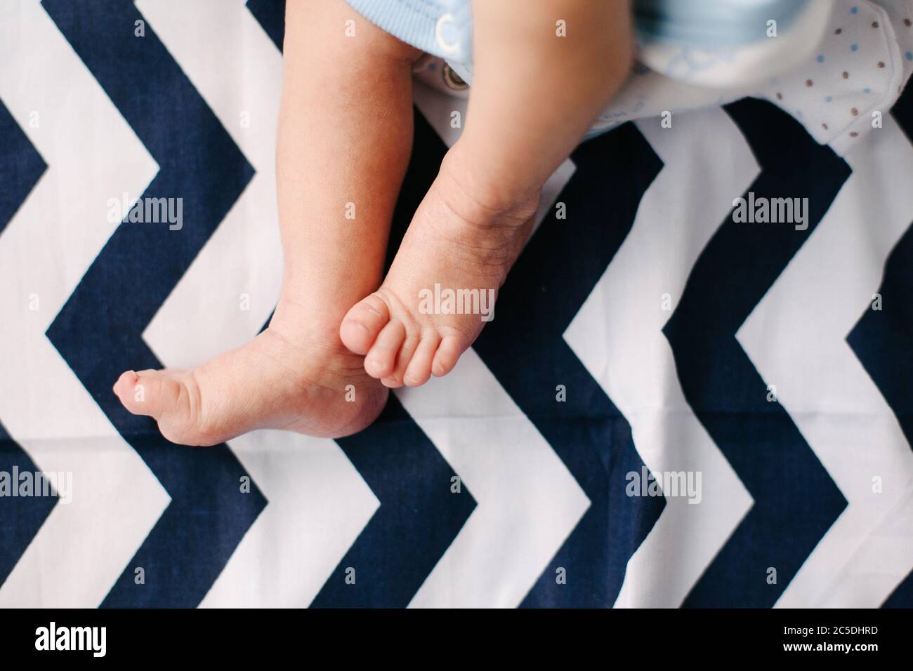 Newborn baby feet and legs. Delicate and wrinkled. Weak and scrawny ...