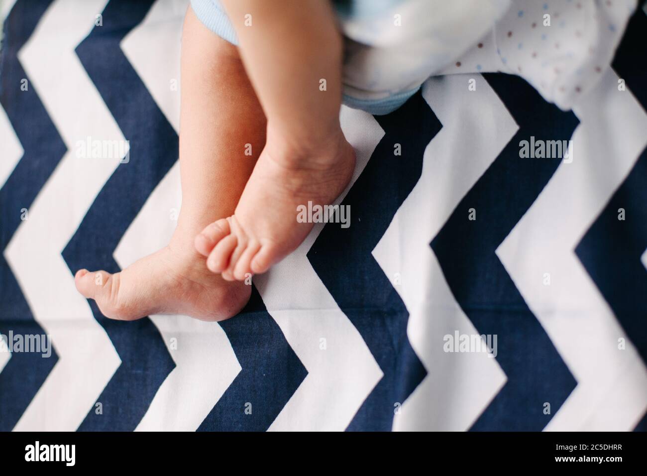Newborn baby feet and legs. Delicate and wrinkled. Weak and scrawny ...
