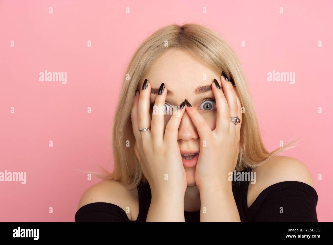 Shocked hiding face. Portrait of young caucasian woman with bright ...