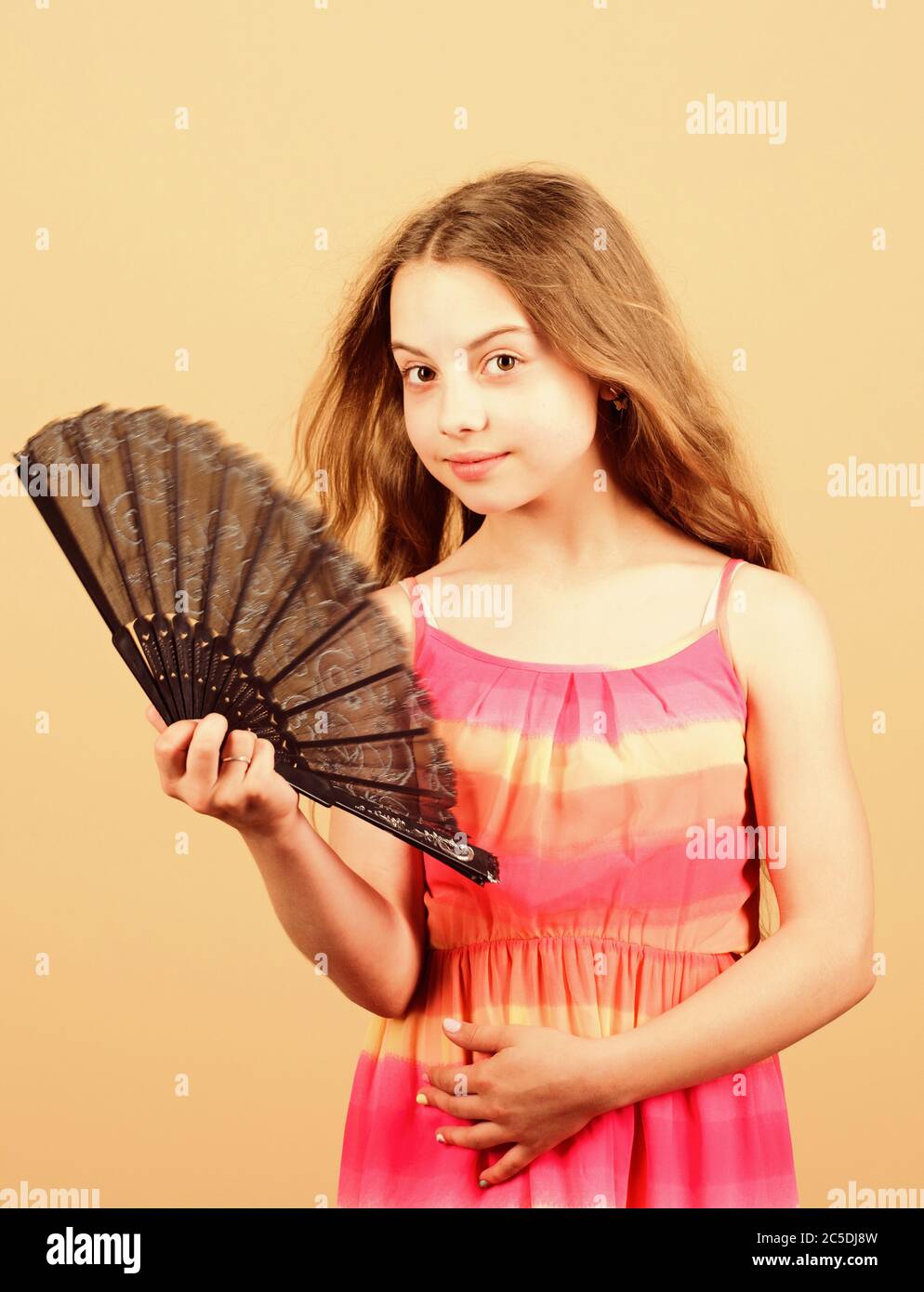 Summer heat. Fresh air. Kid girl fanning herself with fan. Cooling and ...
