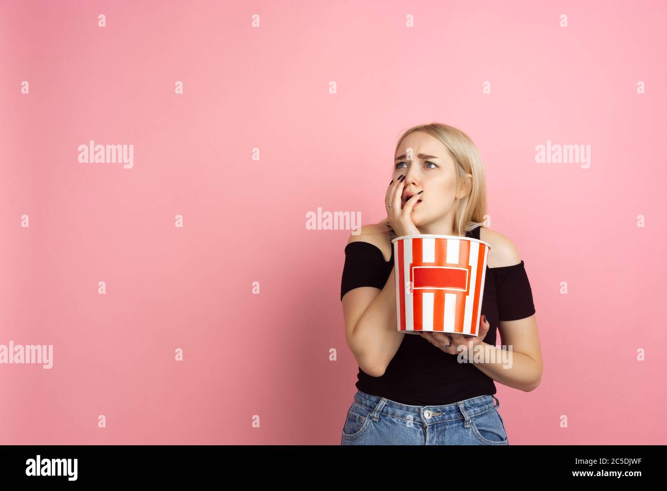 Scared. Portrait of jumping woman with bright emotions on coral pink ...