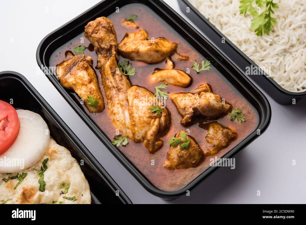 Indian Red Chicken curry packed for home delivery in plastic container ...