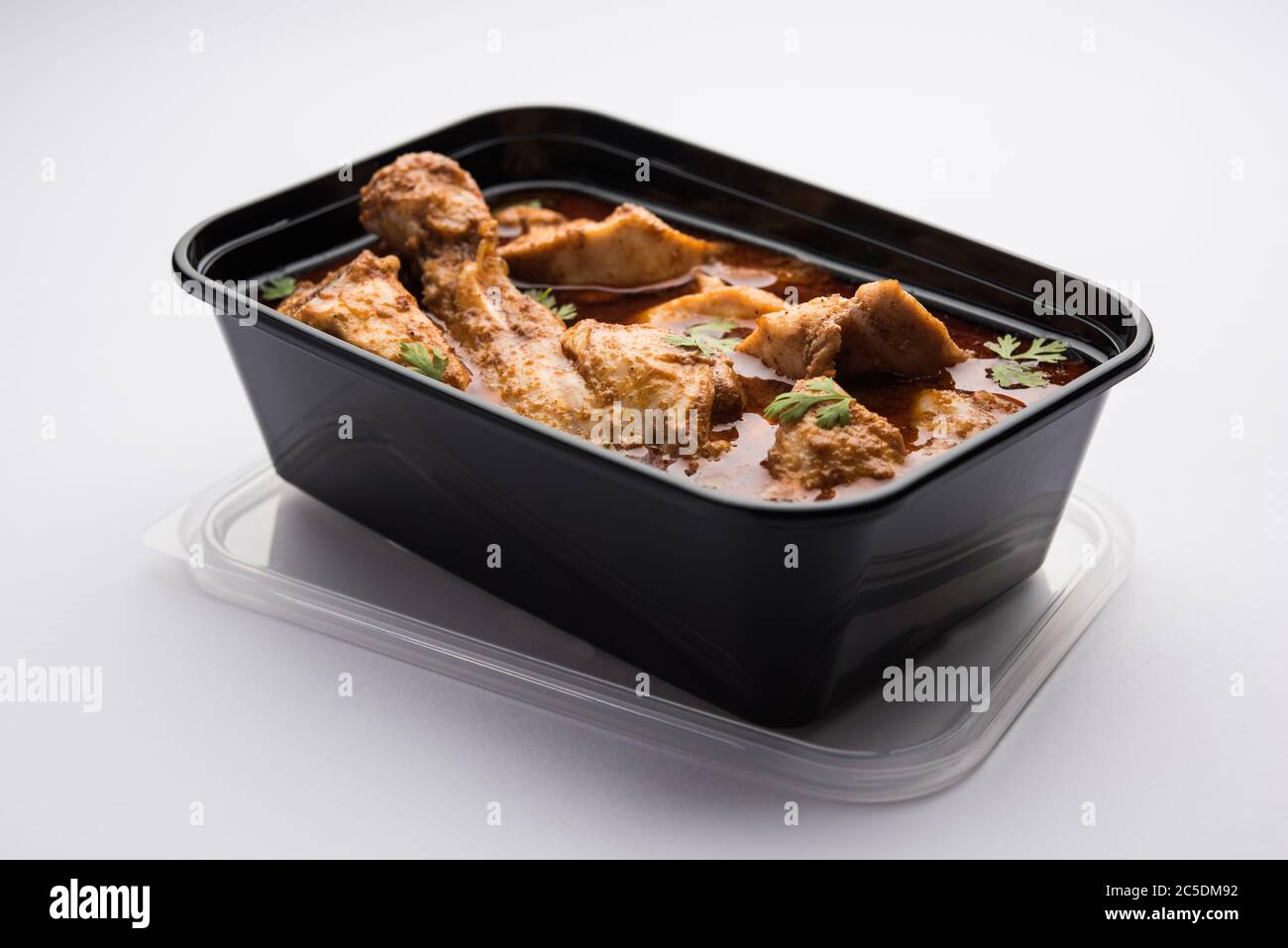 Indian Red Chicken curry packed for home delivery in plastic container ...