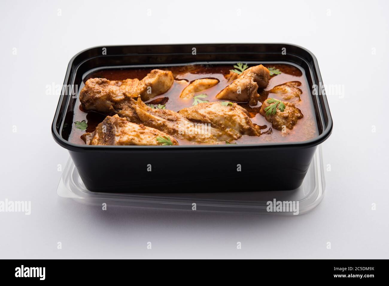 Indian Red Chicken curry packed for home delivery in plastic container ...