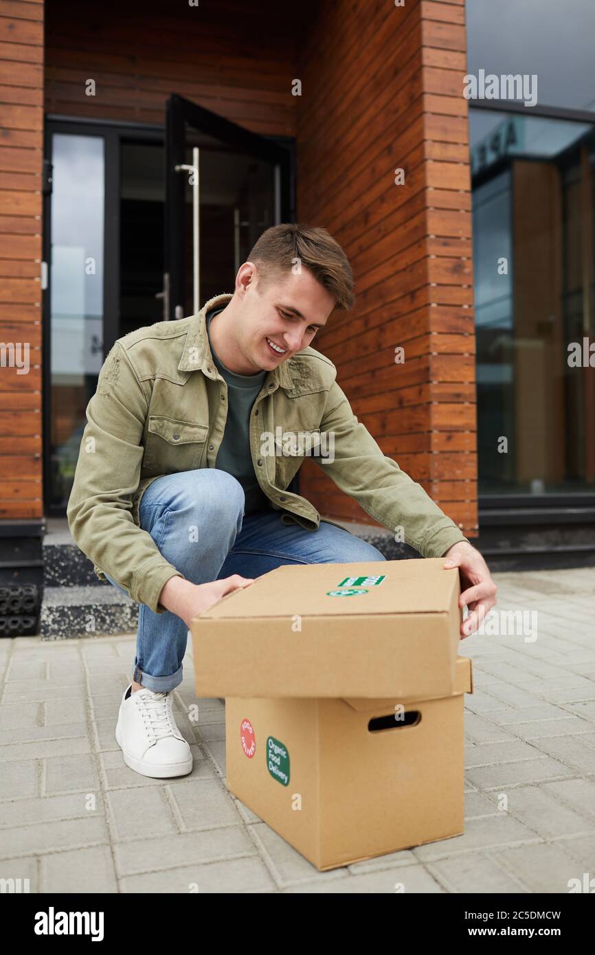 Young man happy because he getting his parcels he sitting outdoors and ...