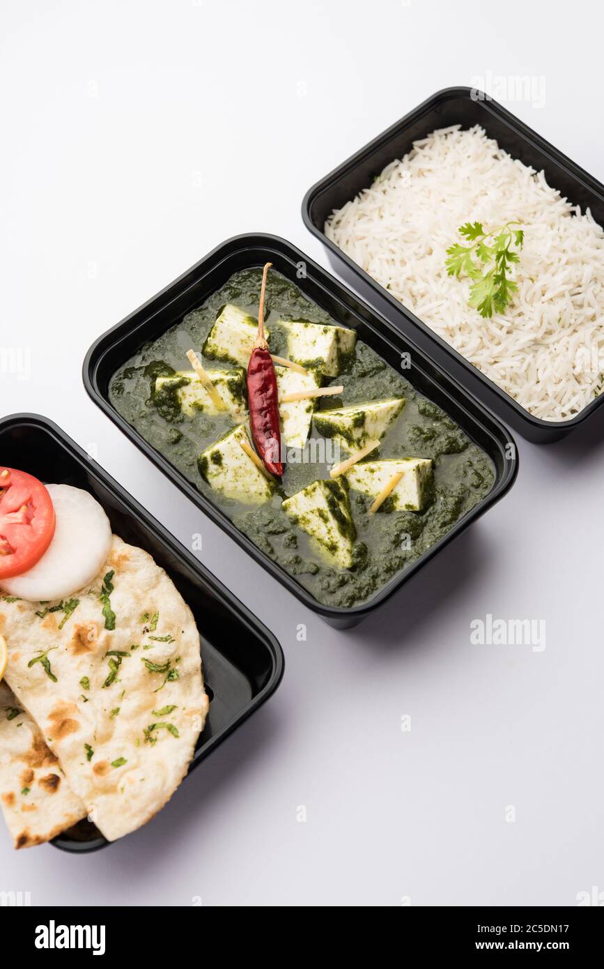 Palak Paneer with rice and chapati packed in a plastic container ready ...
