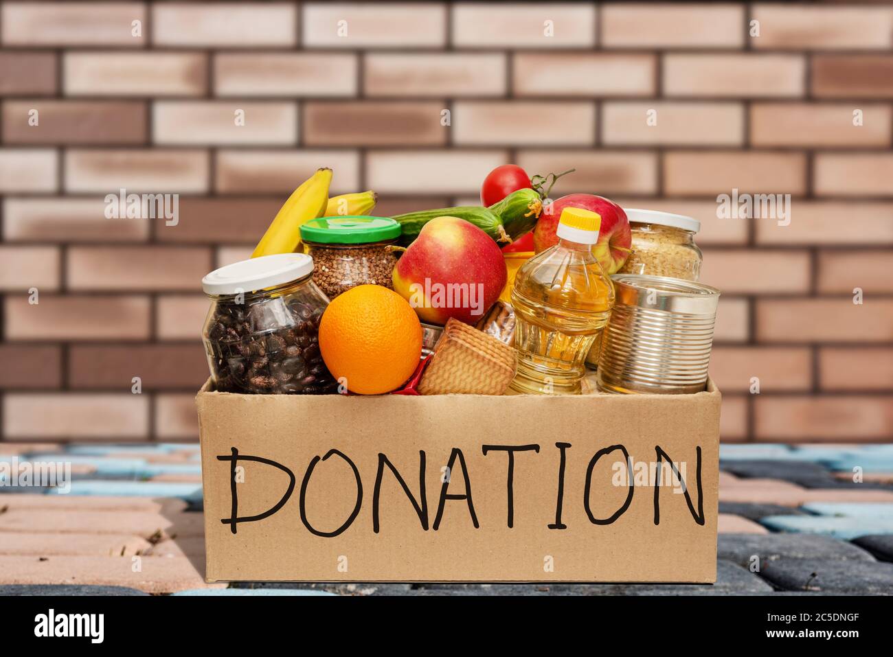 Donation box with food. Open cardboard box with oil, canned food ...