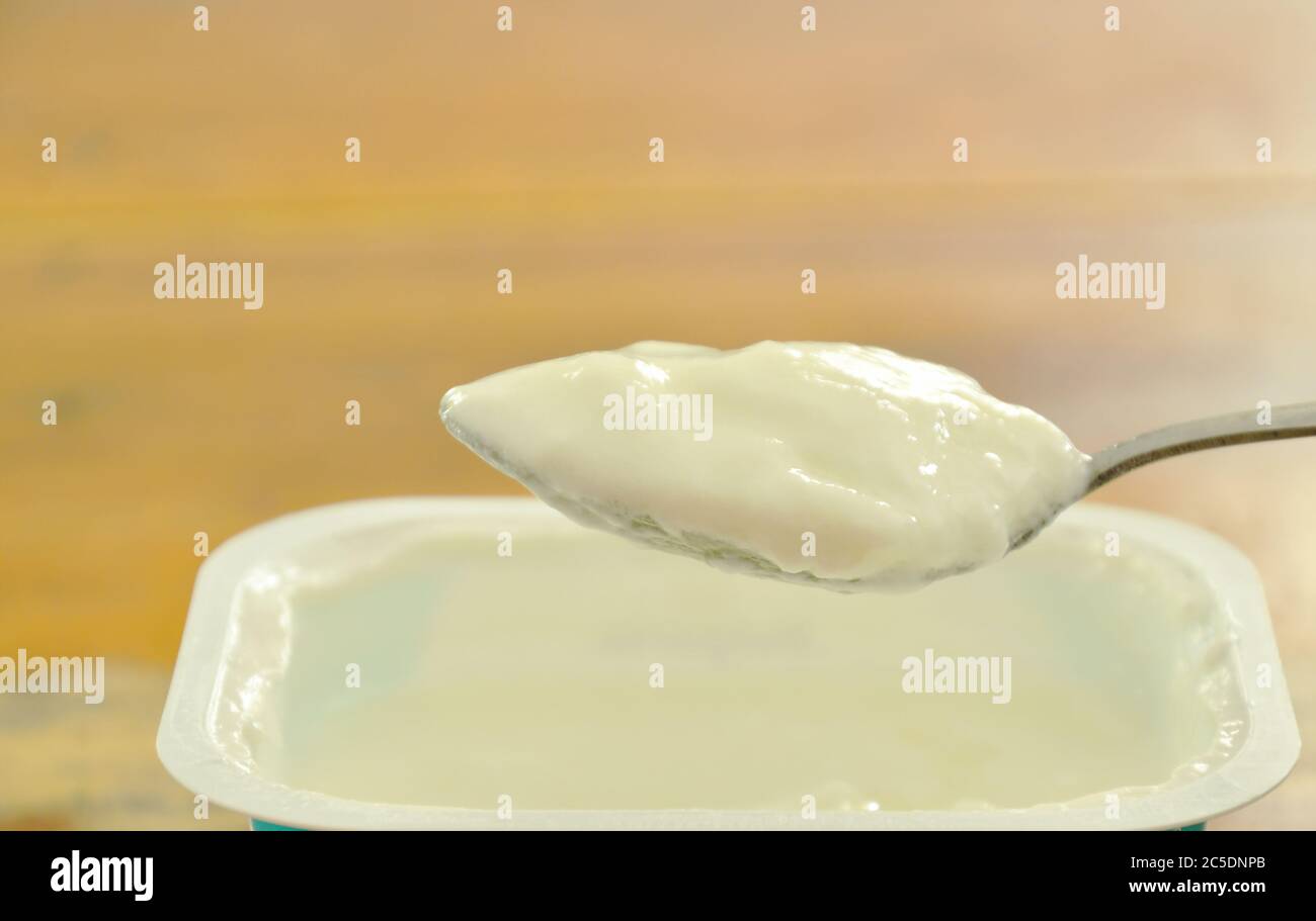 yogurt scooping on spoon from plastic cup Stock Photo - Alamy