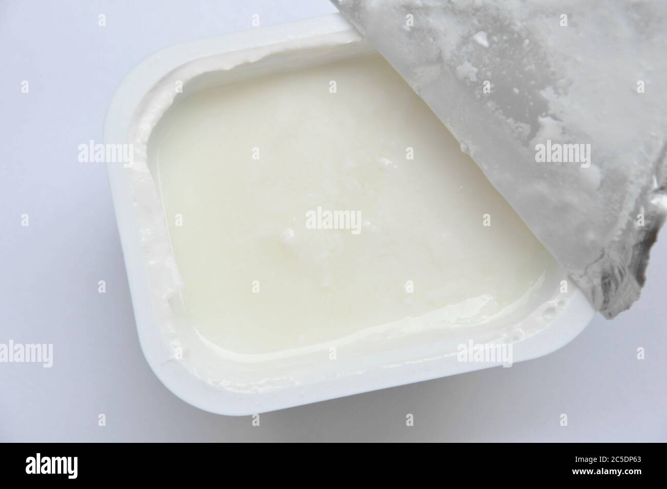 yogurt open from plastic cup on white background Stock Photo - Alamy